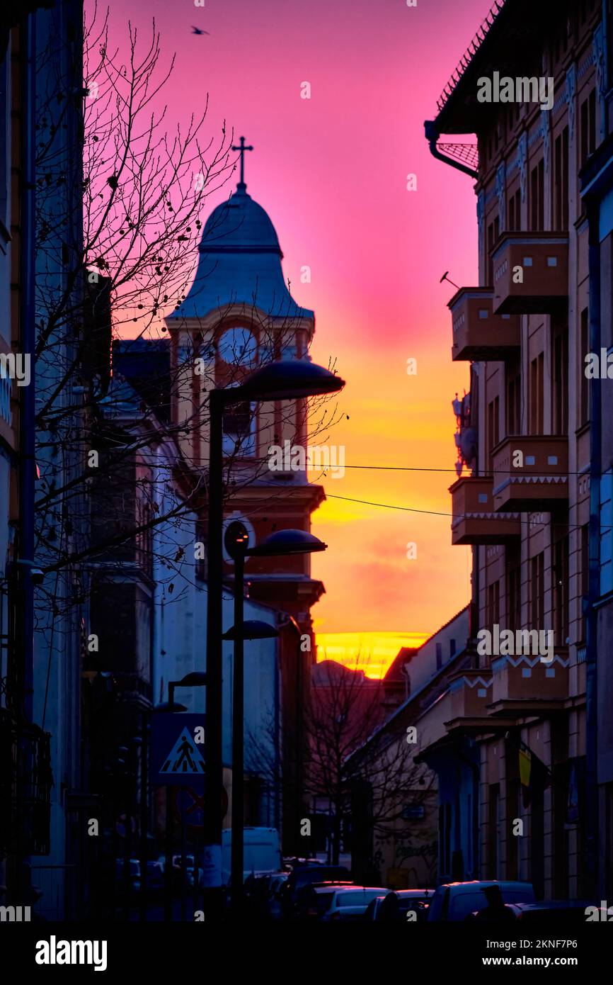 The vertical shot of buildings in Cluj-Napoca before the pink-shaded ...