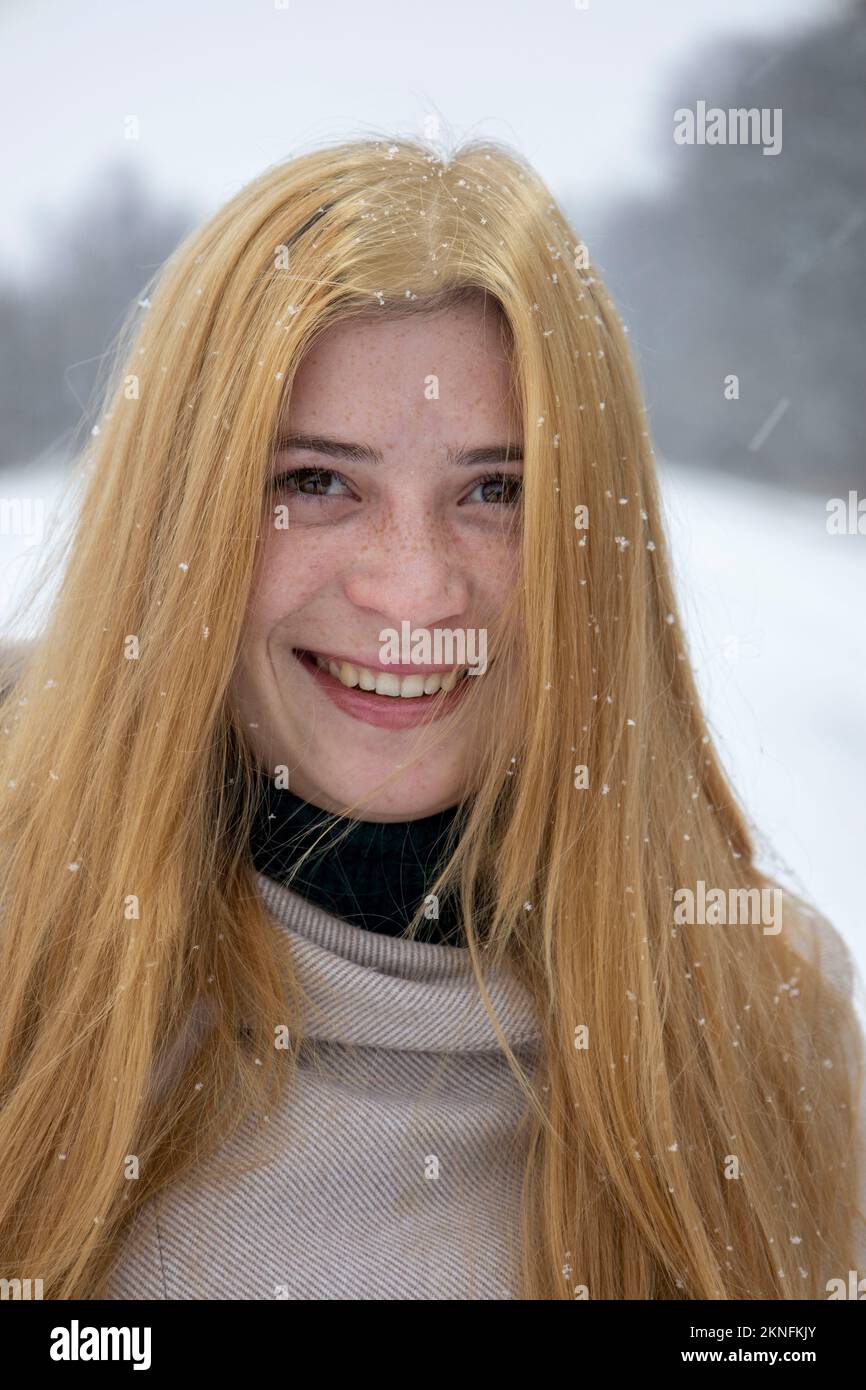Portrait of a red-haired girl with freckles on her face. With blurred ...