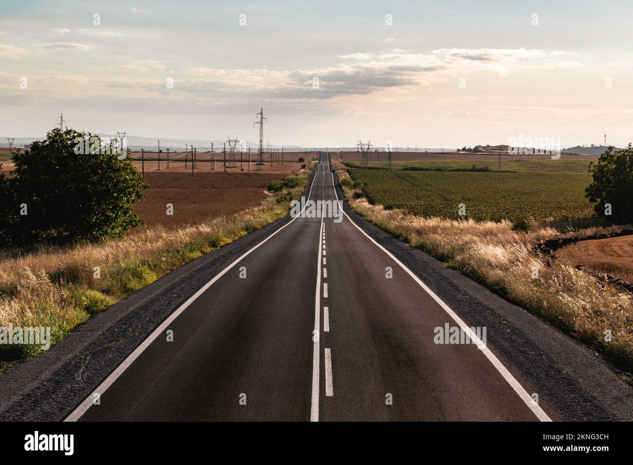 A highway road through the farmlands at warm sunset Stock Photo - Alamy