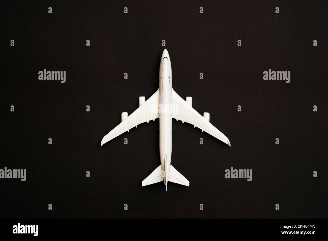 A white plane isolated on a black background. Tourism and travel ...