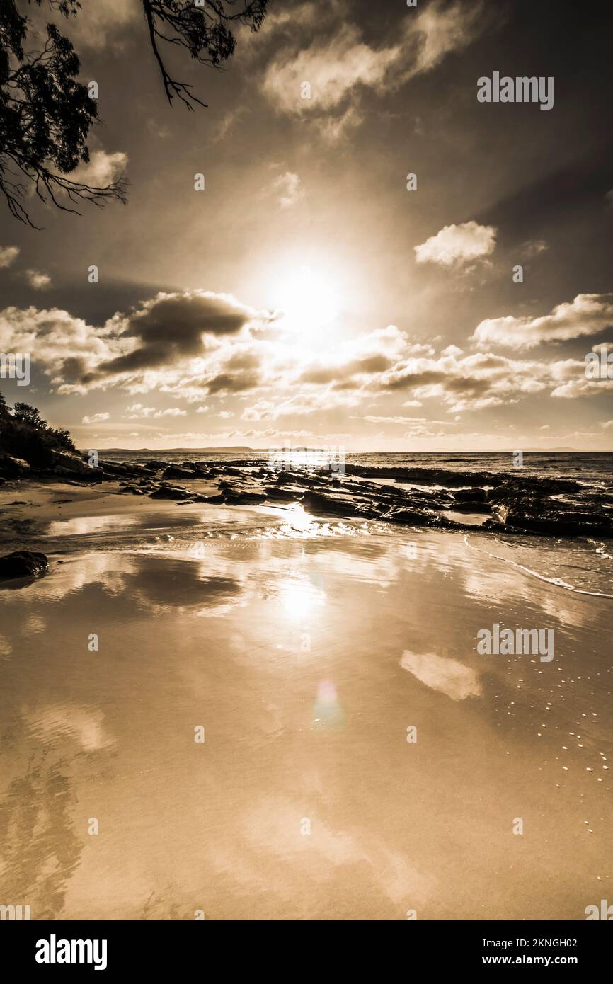 Vertical HDR landscape of a coastal shore with sunlight and reflecting ...
