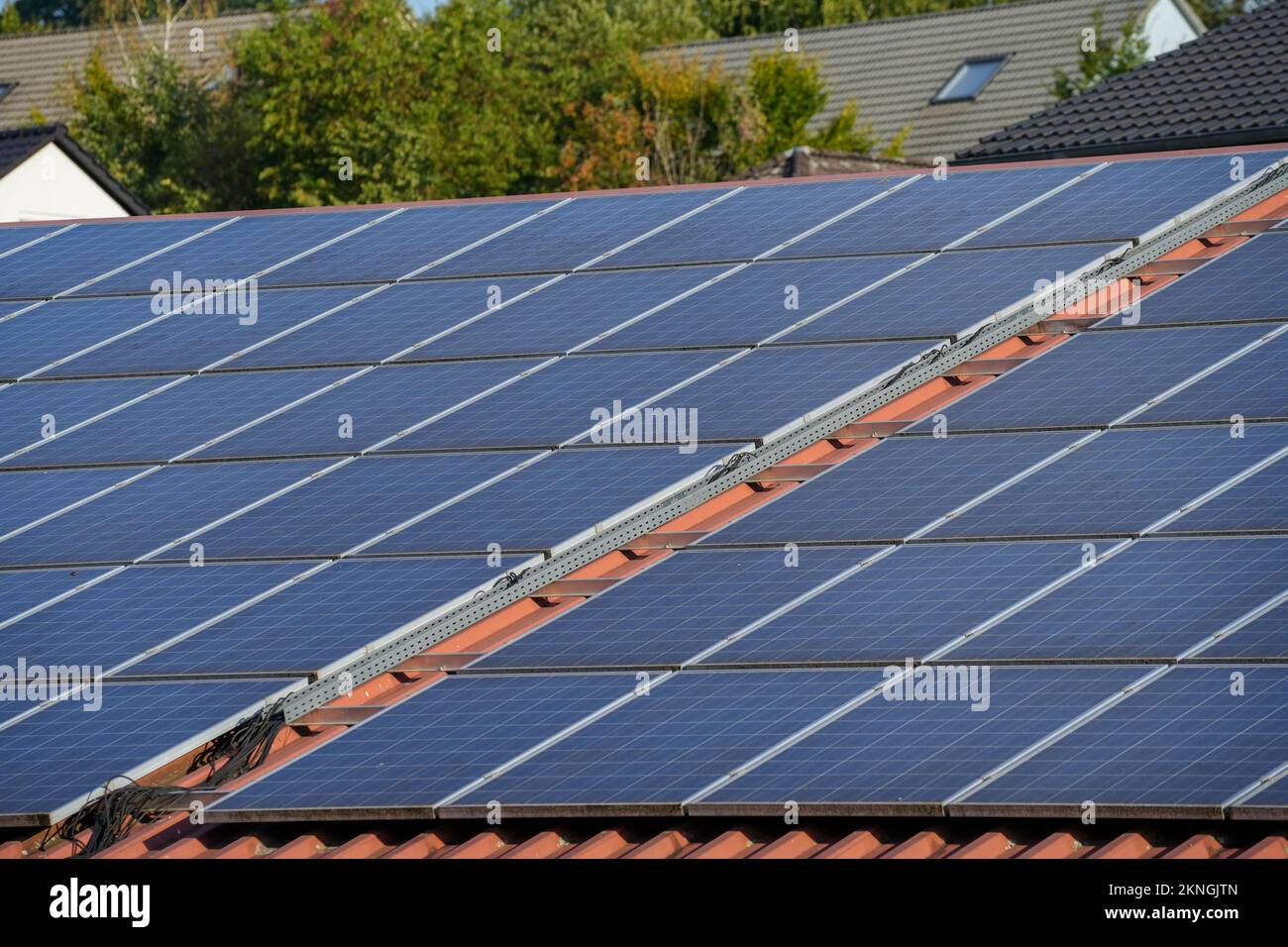 A bunch of solar panels on roofs of a residential neighborhood ...