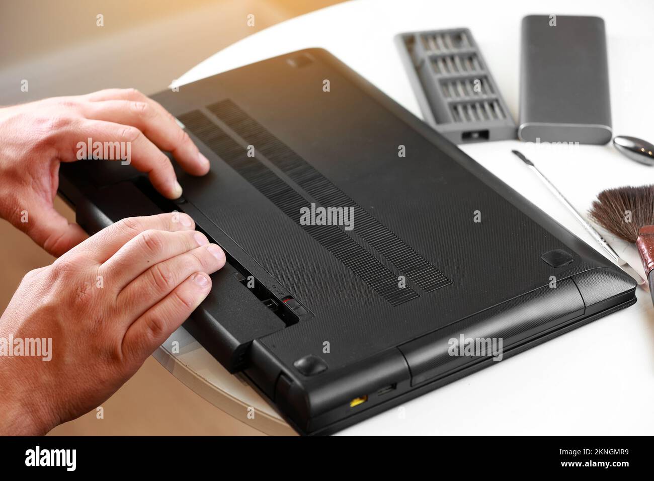 Repairman's hands removing the power battery from the laptop. Computer ...