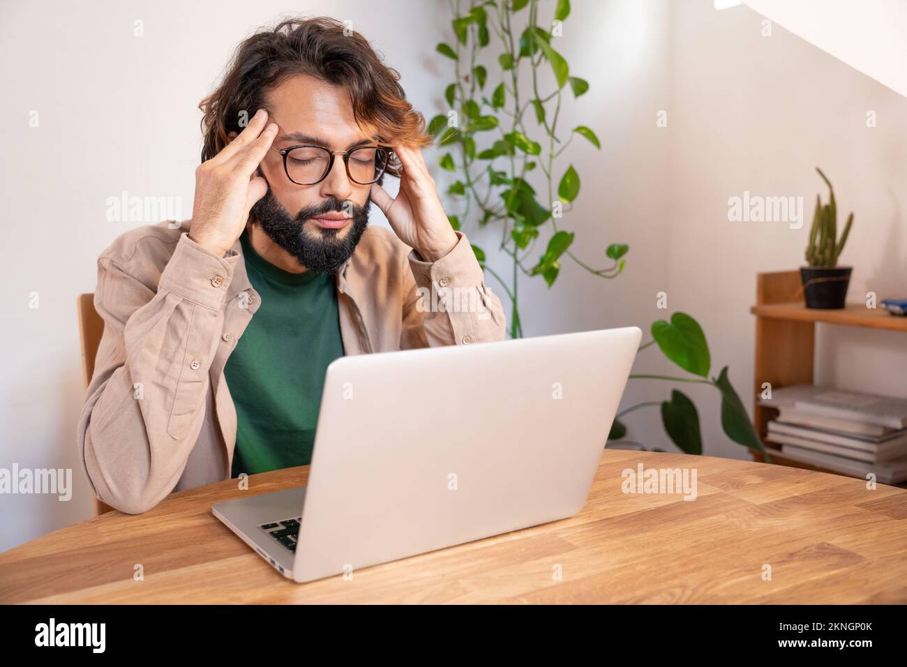Stressed tired businessman suffering from headache working from home ...