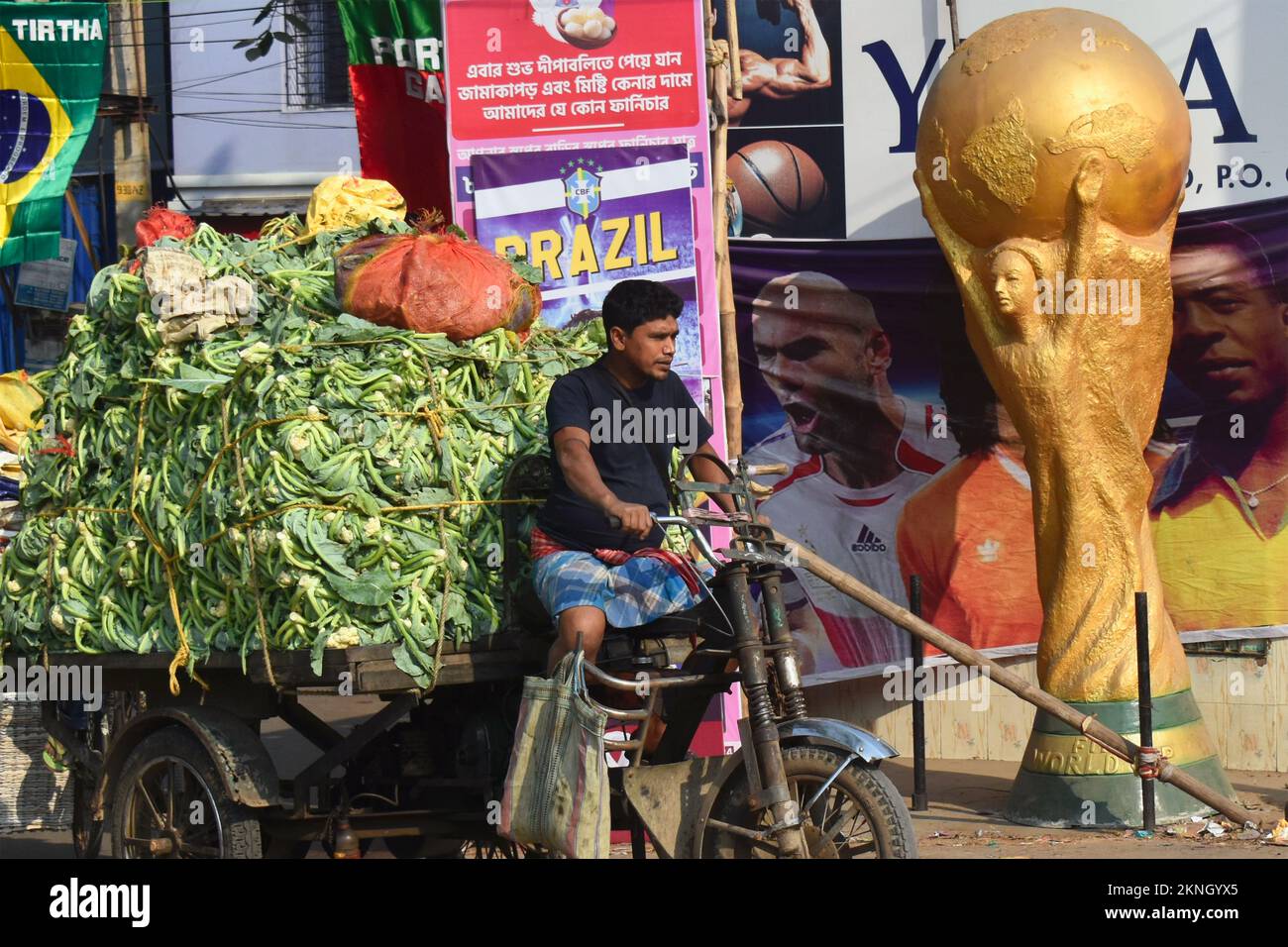 Kolkata, India. 27th Nov, 2022. A vegetable seller passes next to a ...