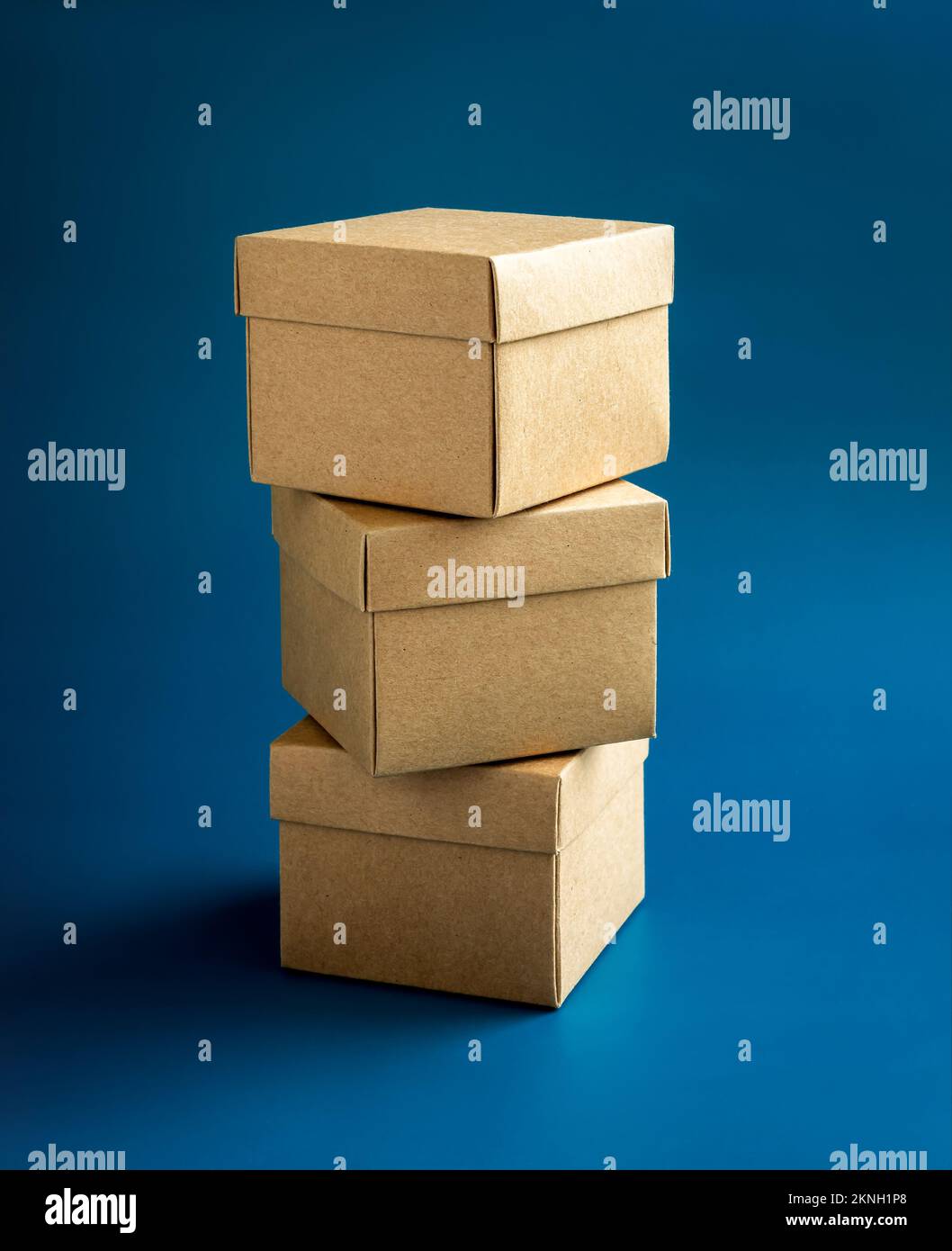 Three cardboard parcel boxes stack on blue background, vertical style ...