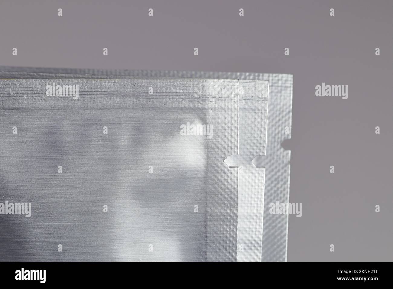 Close up of tear point on sheet foil package. silver plastic sachet ...
