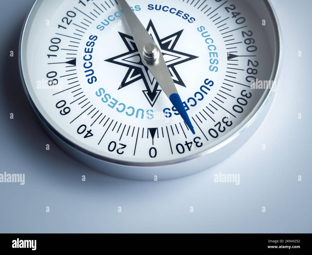 Closeup blue words "SUCCESS" on compass dial in businessman's hand on ...