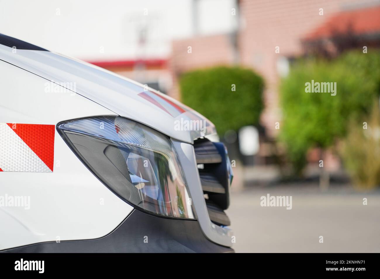 A side view closeup of the headlight of white car parked outside Stock ...