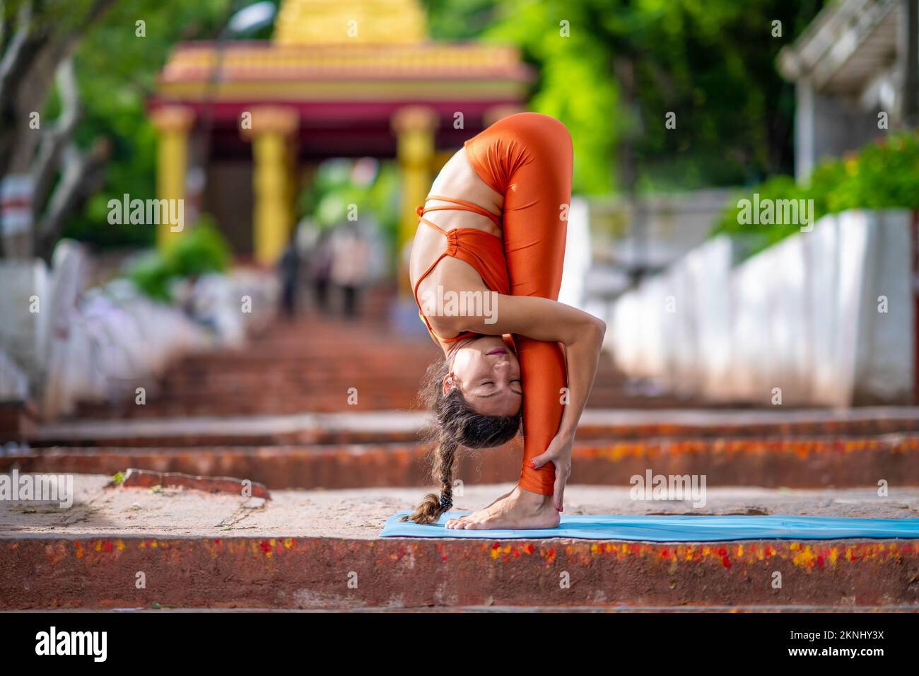A scenic view of a Caucasian woman doing yoga poses inside an Indian ...