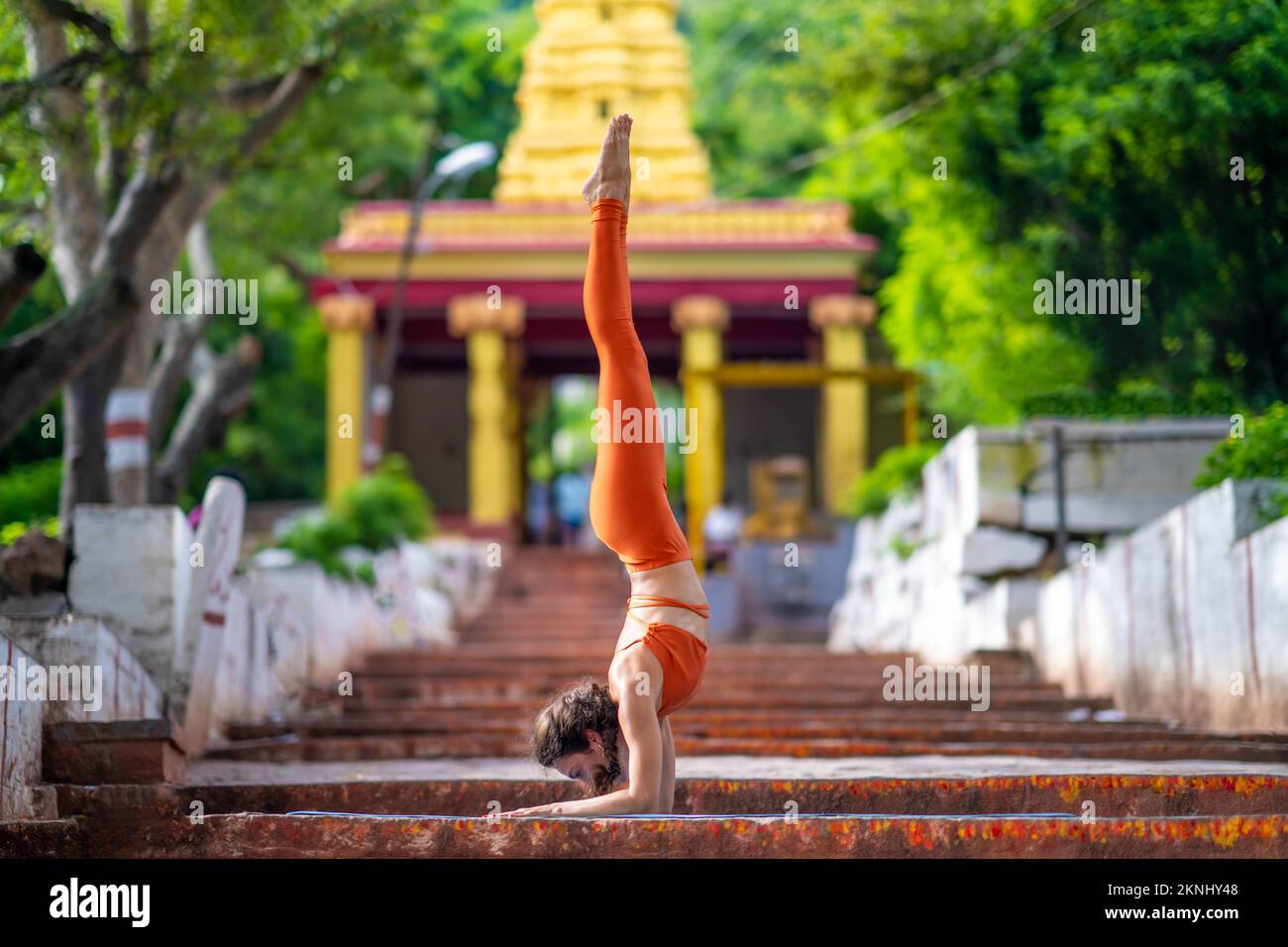 A scenic view of a Caucasian woman doing yoga poses inside an Indian ...