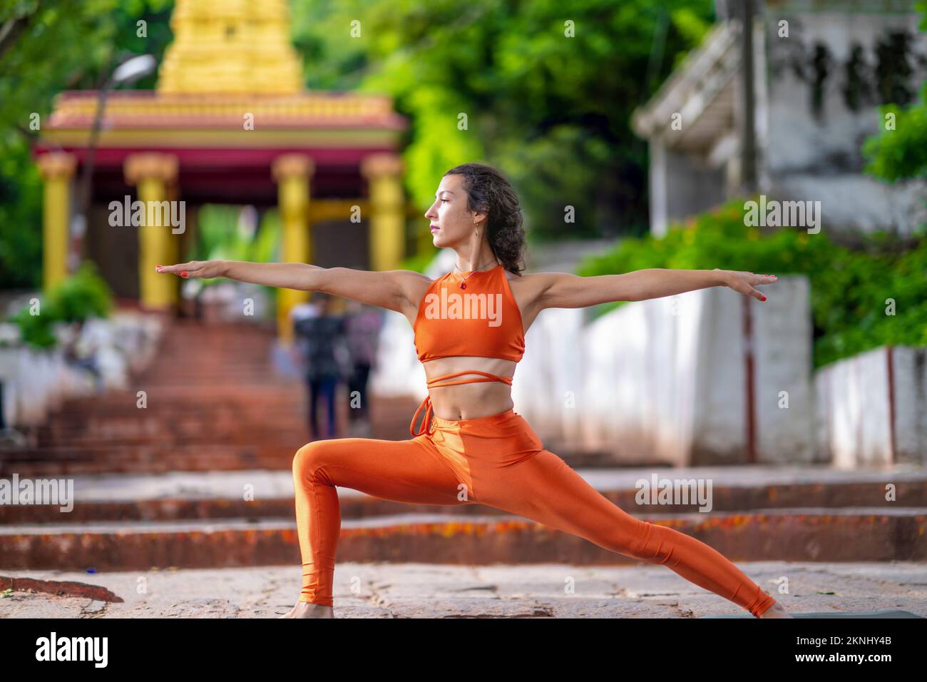 A scenic view of a Caucasian woman doing yoga poses inside an Indian ...