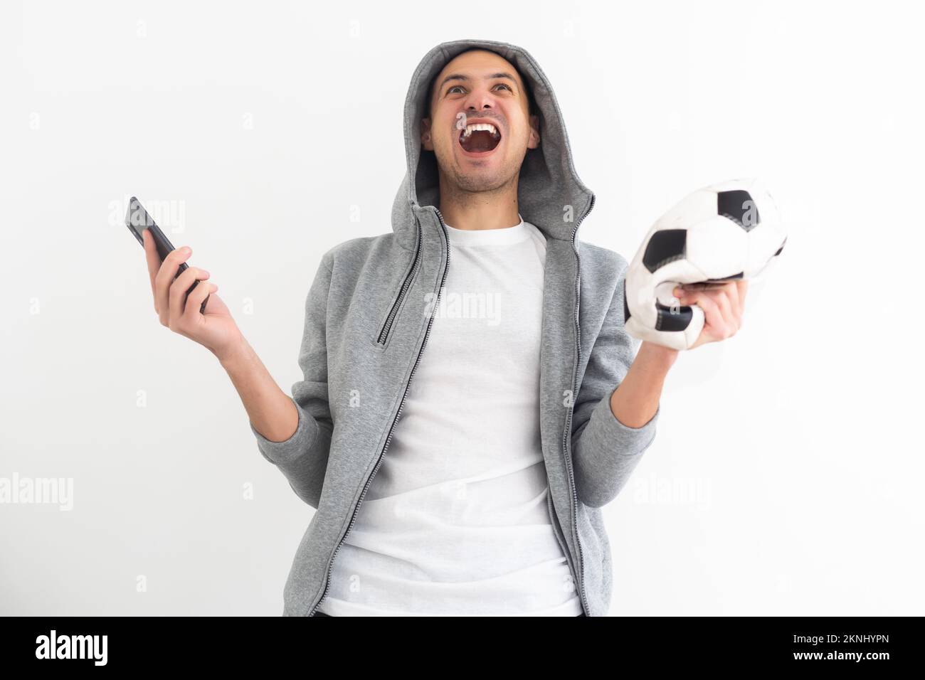 shocked football fan in blue t-shirt using smartphone and holding ...