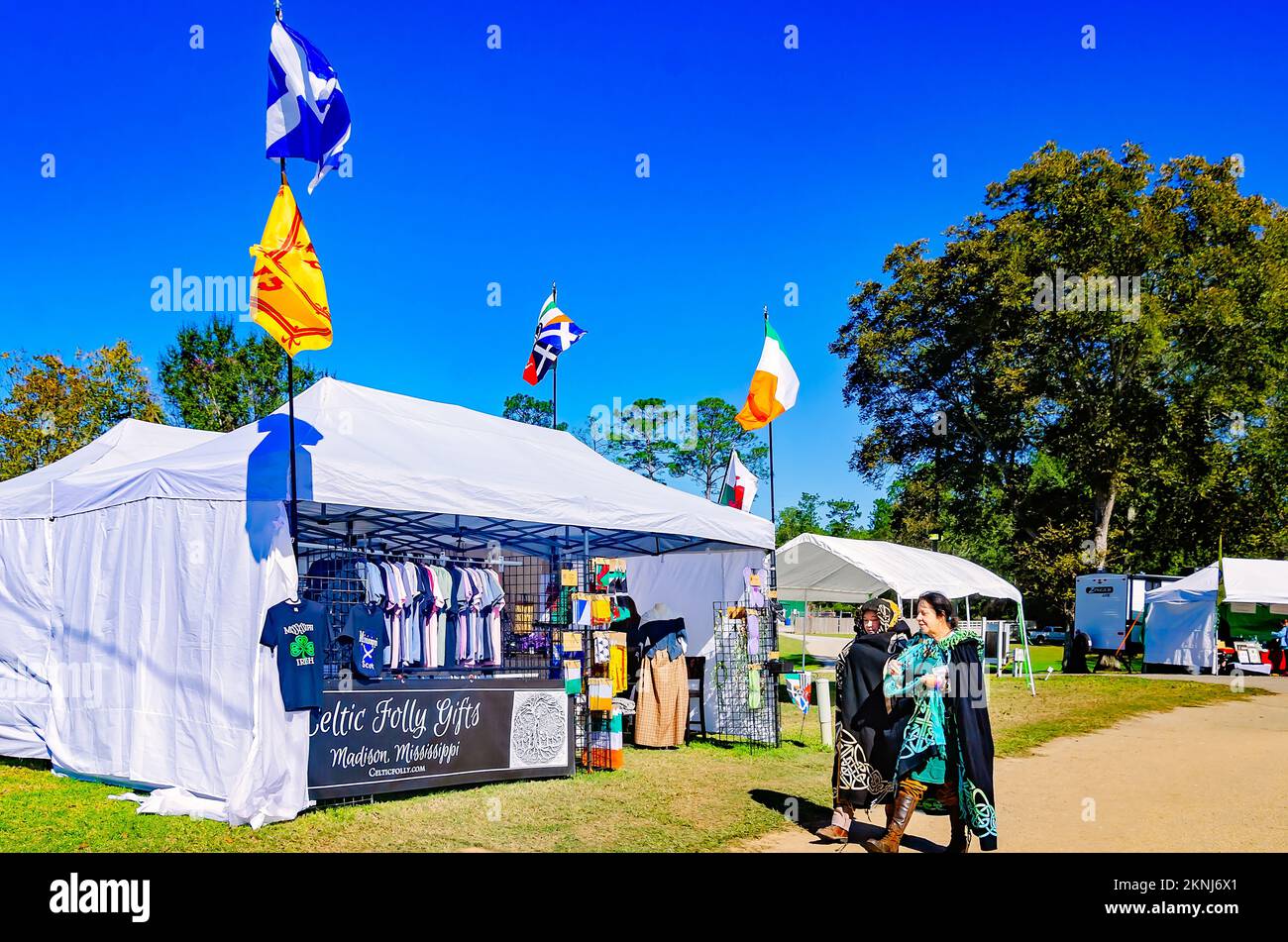Two women in costume walk past a vendor’s booth during the annual ...
