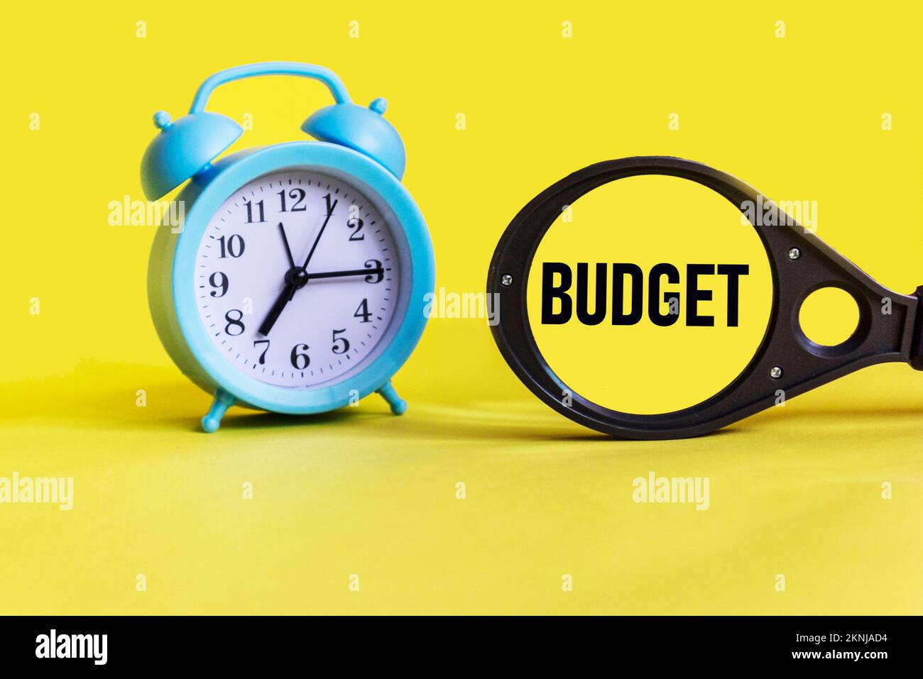 The word BUDGET on a magnifying glass on a yellow background with a ...