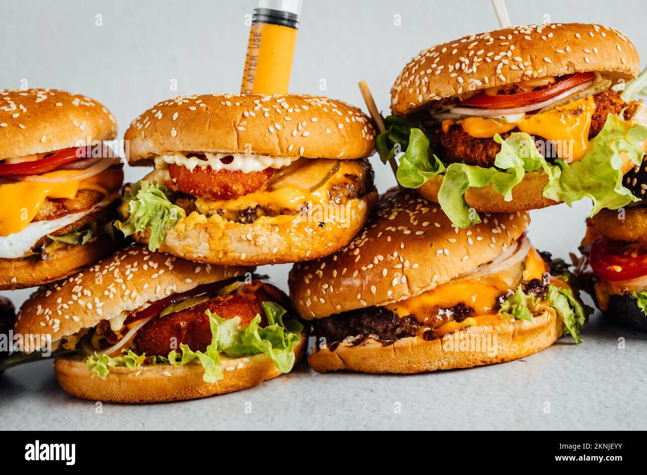 The delicious fresh and juicy burgers with syringe stacked on each ...