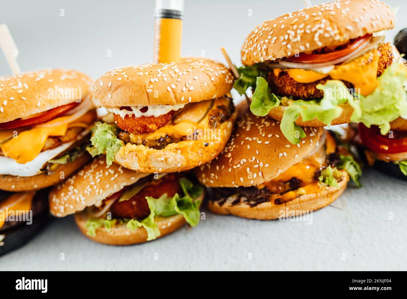 The delicious fresh and juicy burgers with syringe stacked on each ...