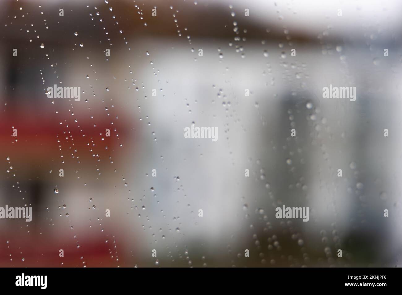 Raindrops on the window glass. Blurred view of the objects outside the ...
