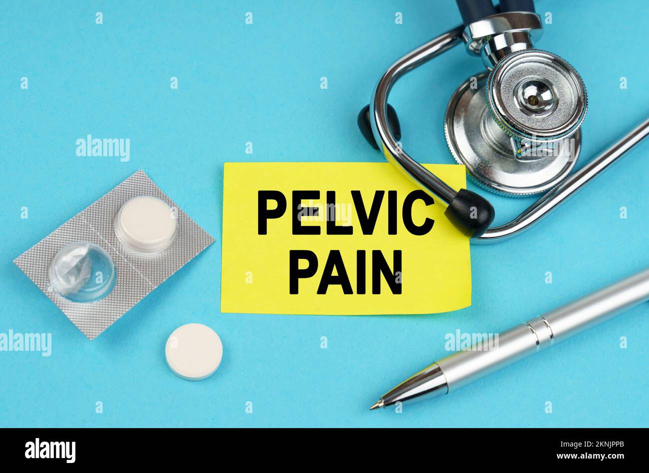 Medical concept. On a blue surface, a stethoscope, pills, a pen and a ...
