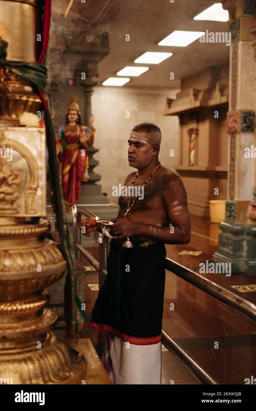 A Hindu priest performing a puja ceremony inside Sri Mahamariamman ...