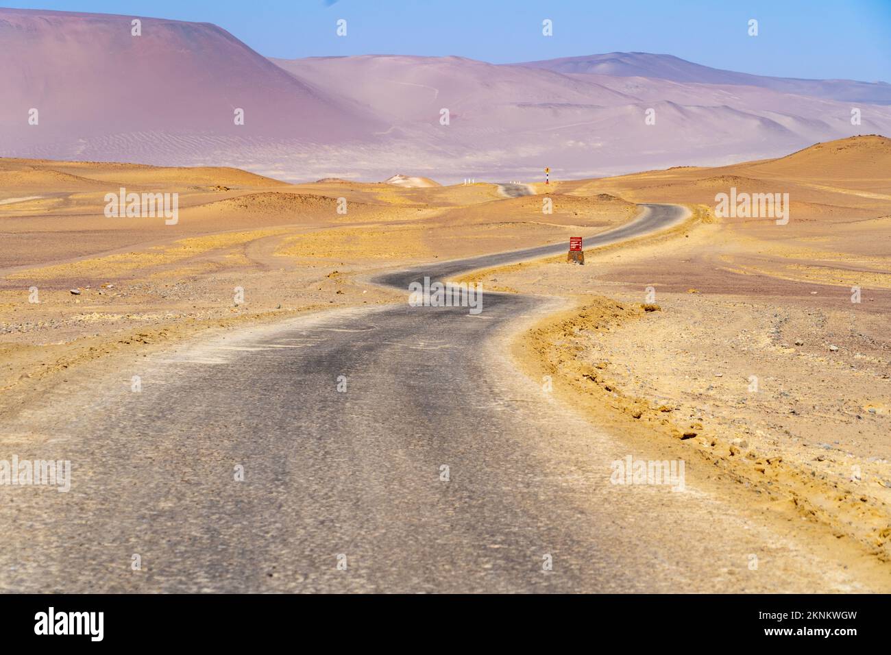 A beautiful shot of a road in the middle of a sandy desert in the ...