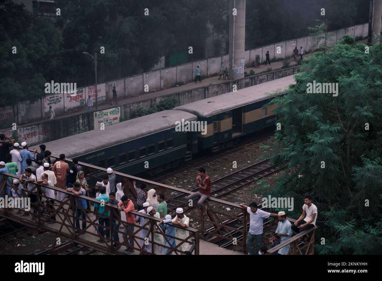 A group of people enjoying the sunset from a foot-over bridge in Khilgaon Stock Photo - Alamy