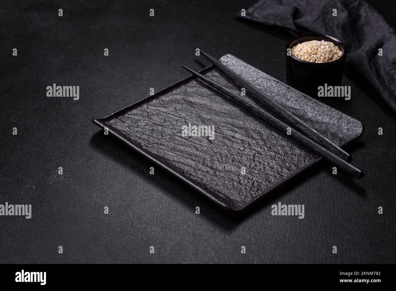 Empty plate with wooden sticks for Asian food on a dark concrete ...