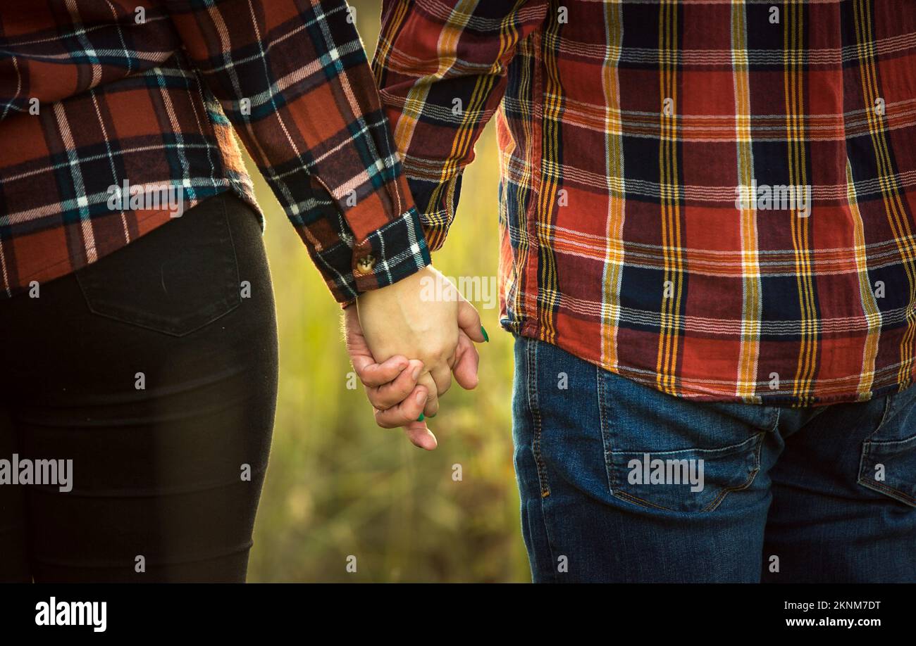 Lovers in the park tenderly hold hands together, blurred background ...