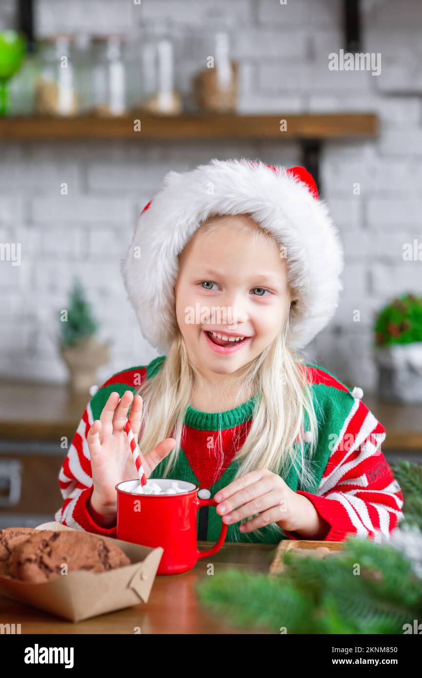 Cute little child girl eating sweet cookies and drinking hot chocolate ...