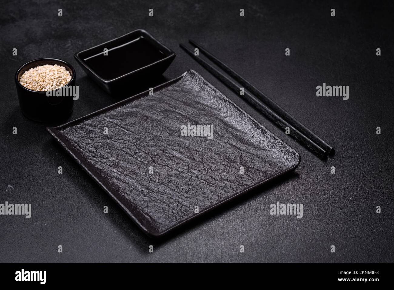 Empty plate with wooden sticks for Asian food on a dark concrete ...