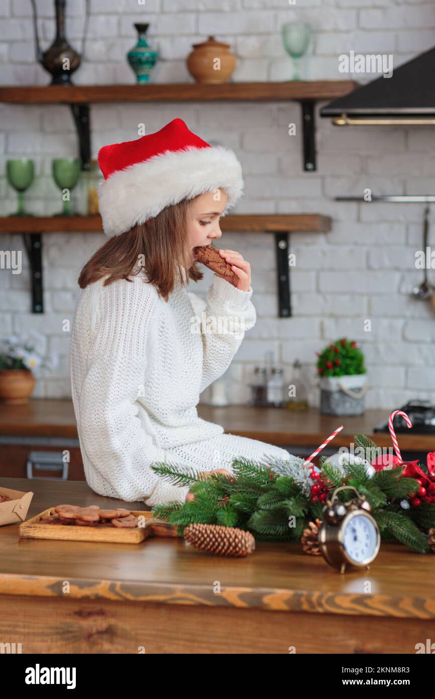 Kid sitting in Christmas decorated cozy kitchen and wearing red santa ...