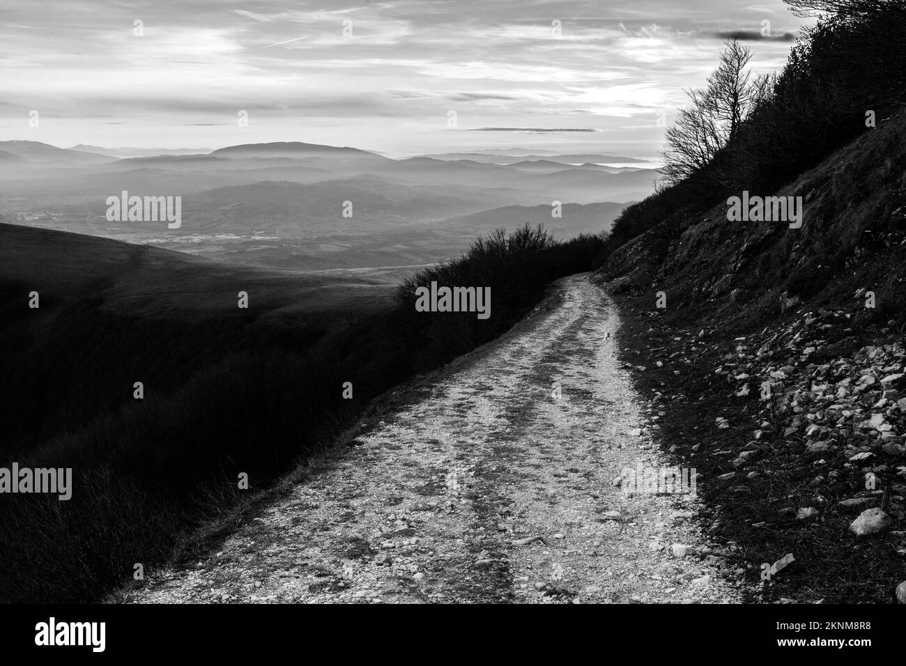 A long, endless mountain road with distant mountains in the background ...