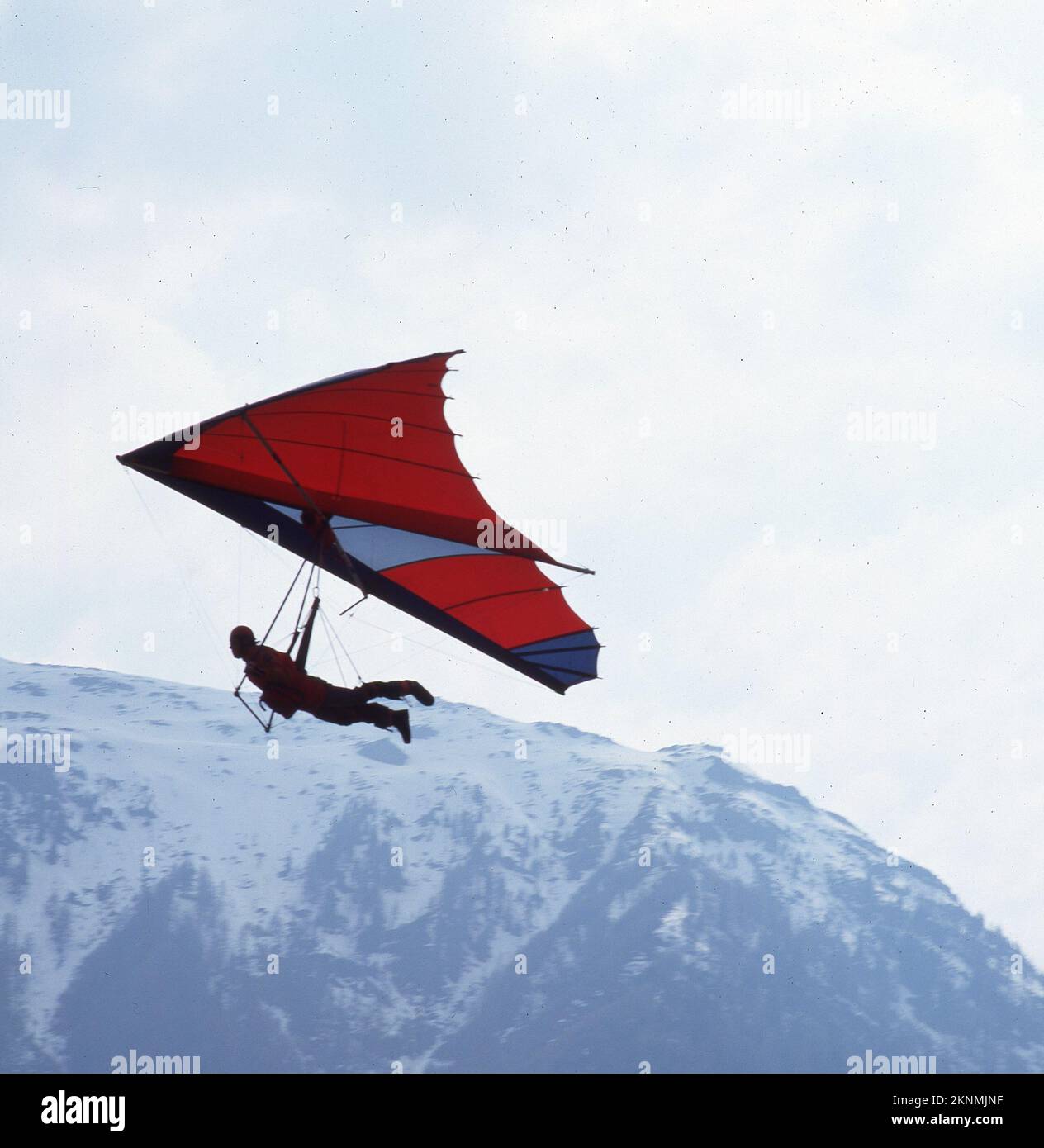A closeup shot of a young man flying over the mountains with his ...