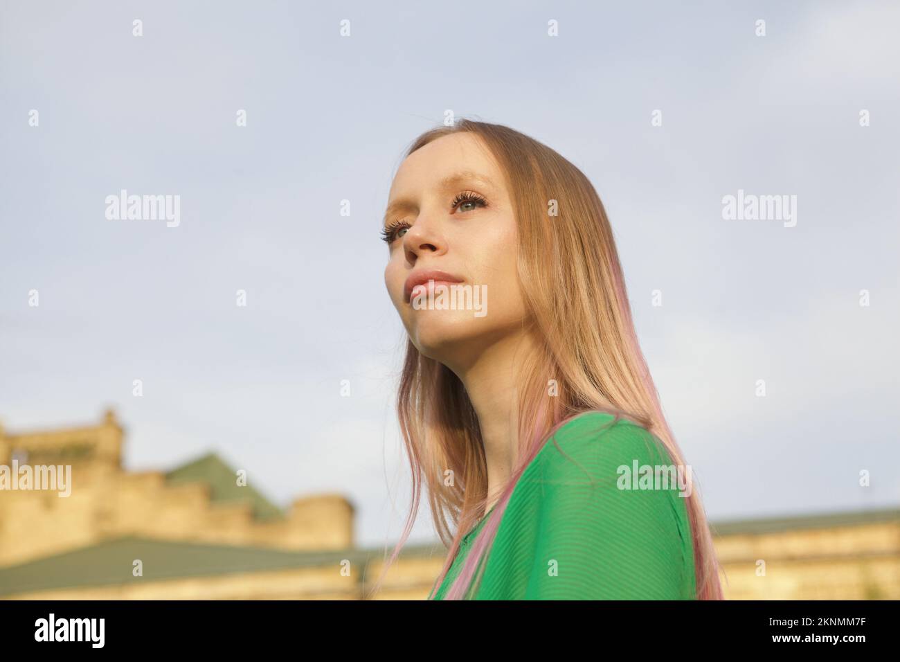 Low angle close up of a gorgeous young woman looking away at sunset ...