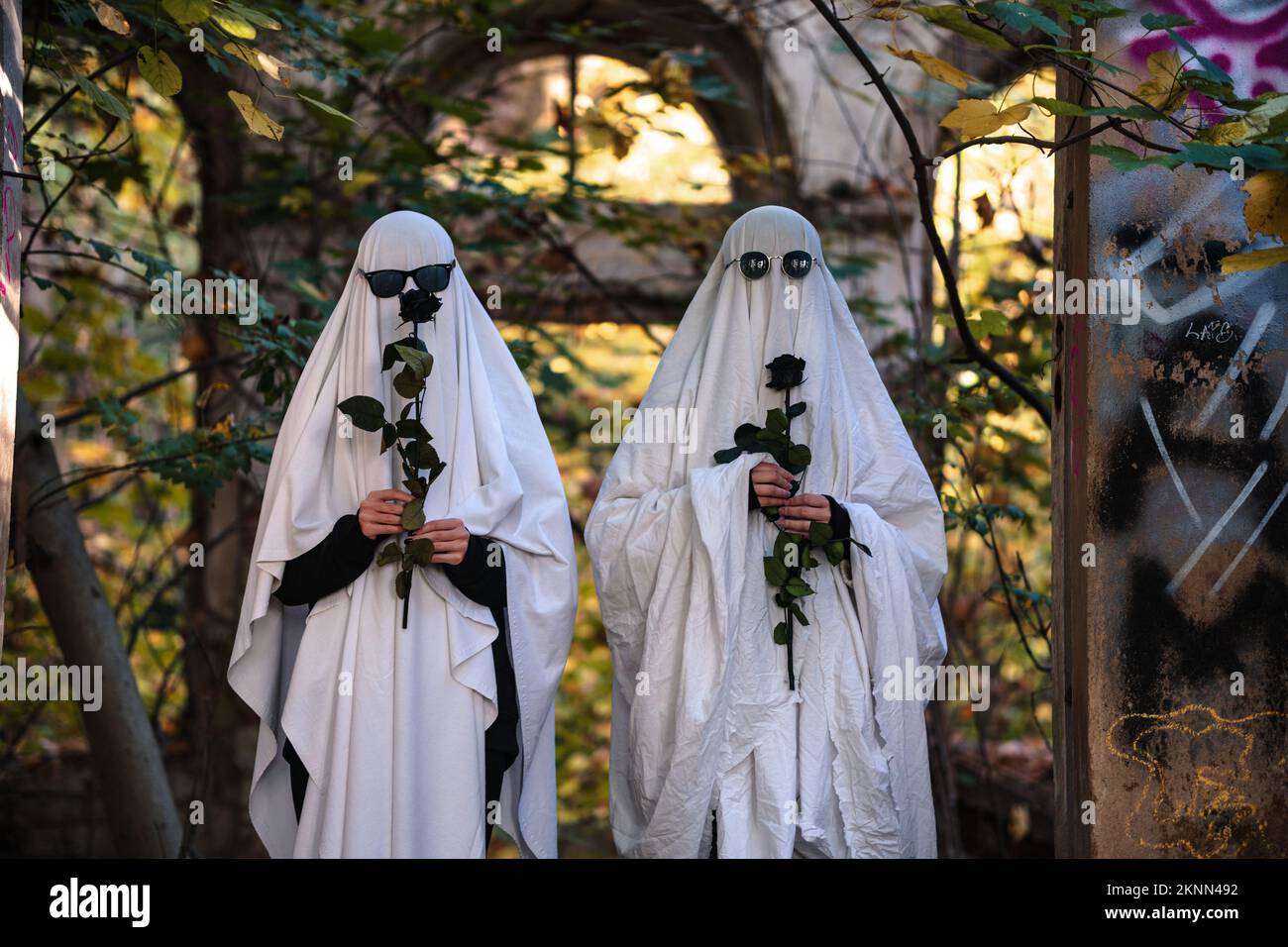 A funny image of two people with black roses in ghost costumes and ...