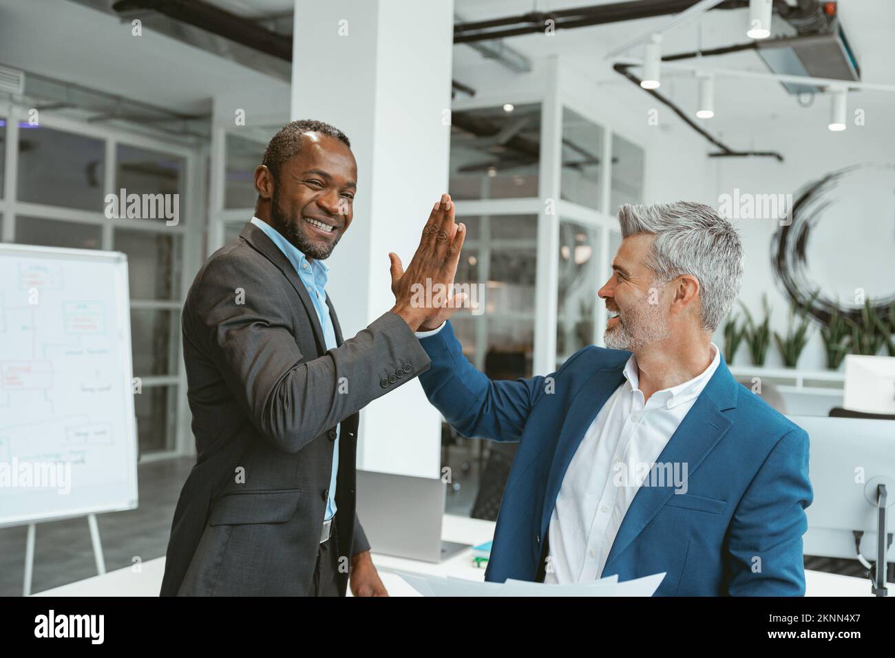 Two multiethnic business colleagues working together in modern office ...