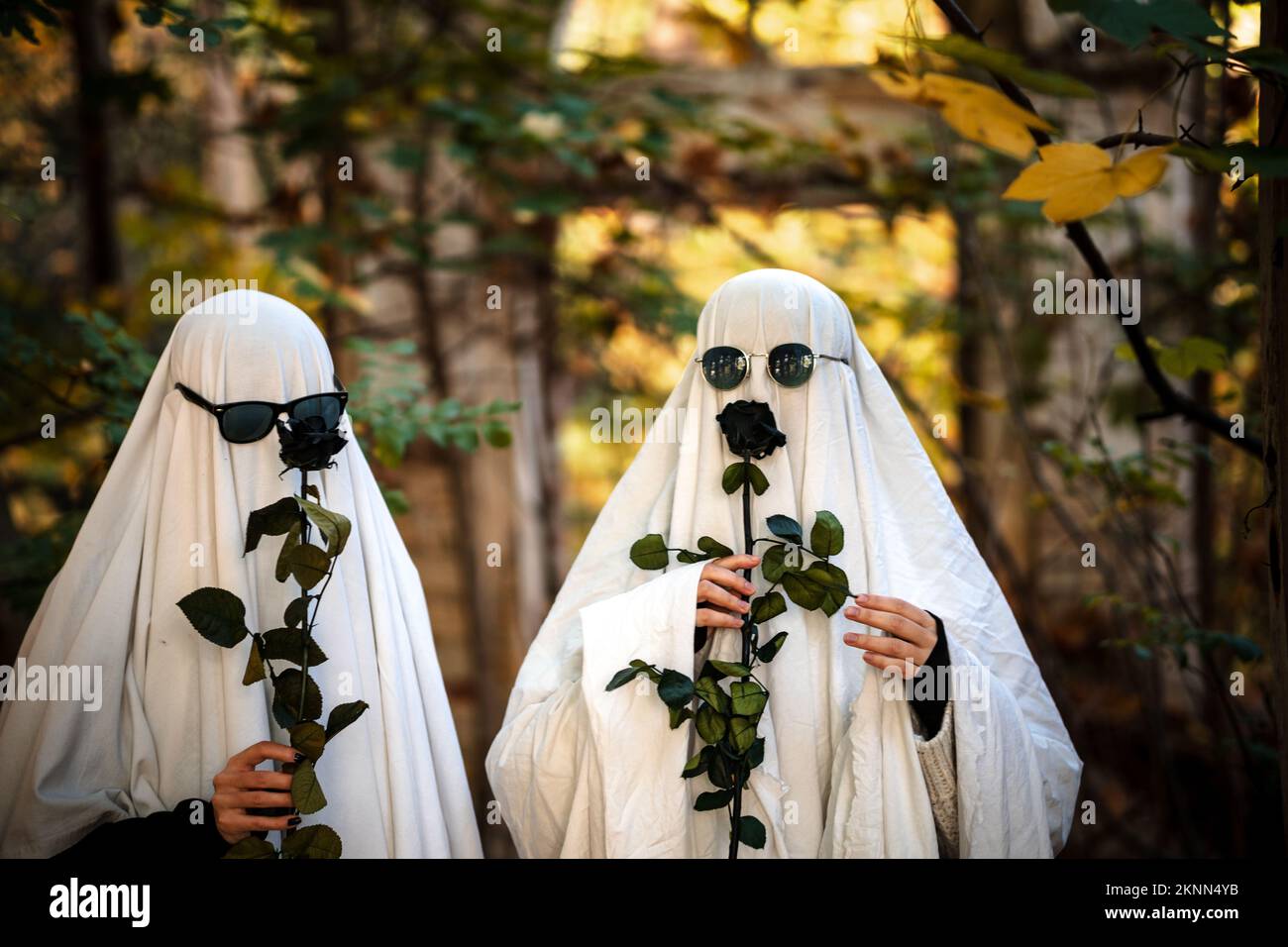 A funny image of two people with black roses in ghost costumes and ...