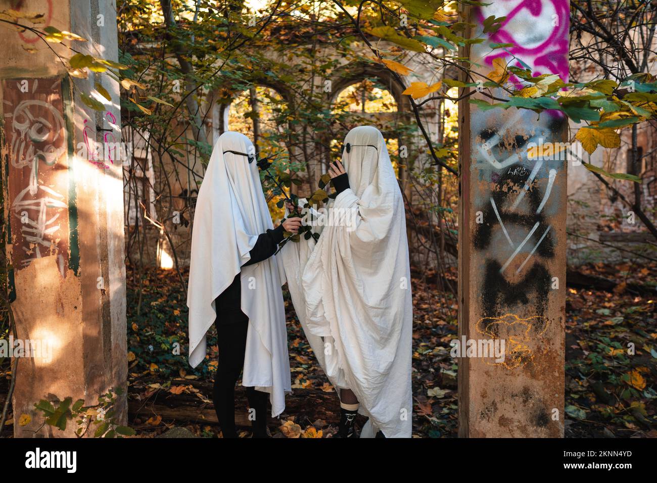 A funny image of two people with black roses in ghost costumes and ...