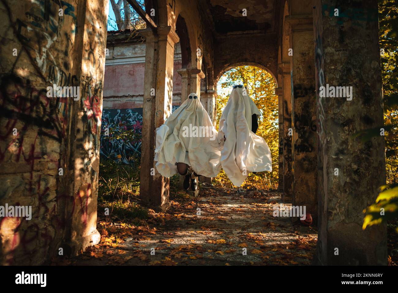 A funny image of two jumping people in ghost costumes and sunglasses in ...