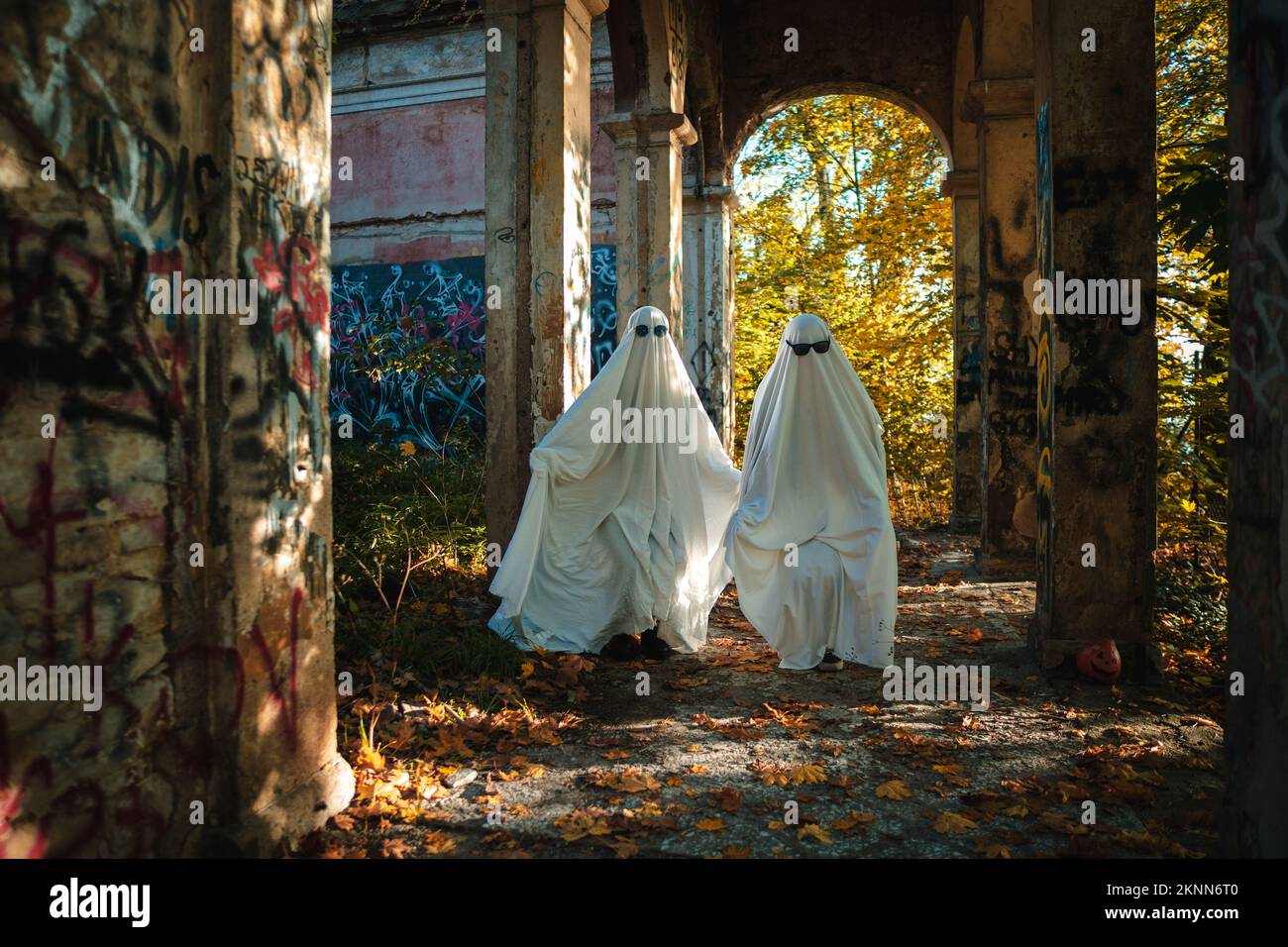 A funny image of two jumping people in ghost costumes and sunglasses in ...