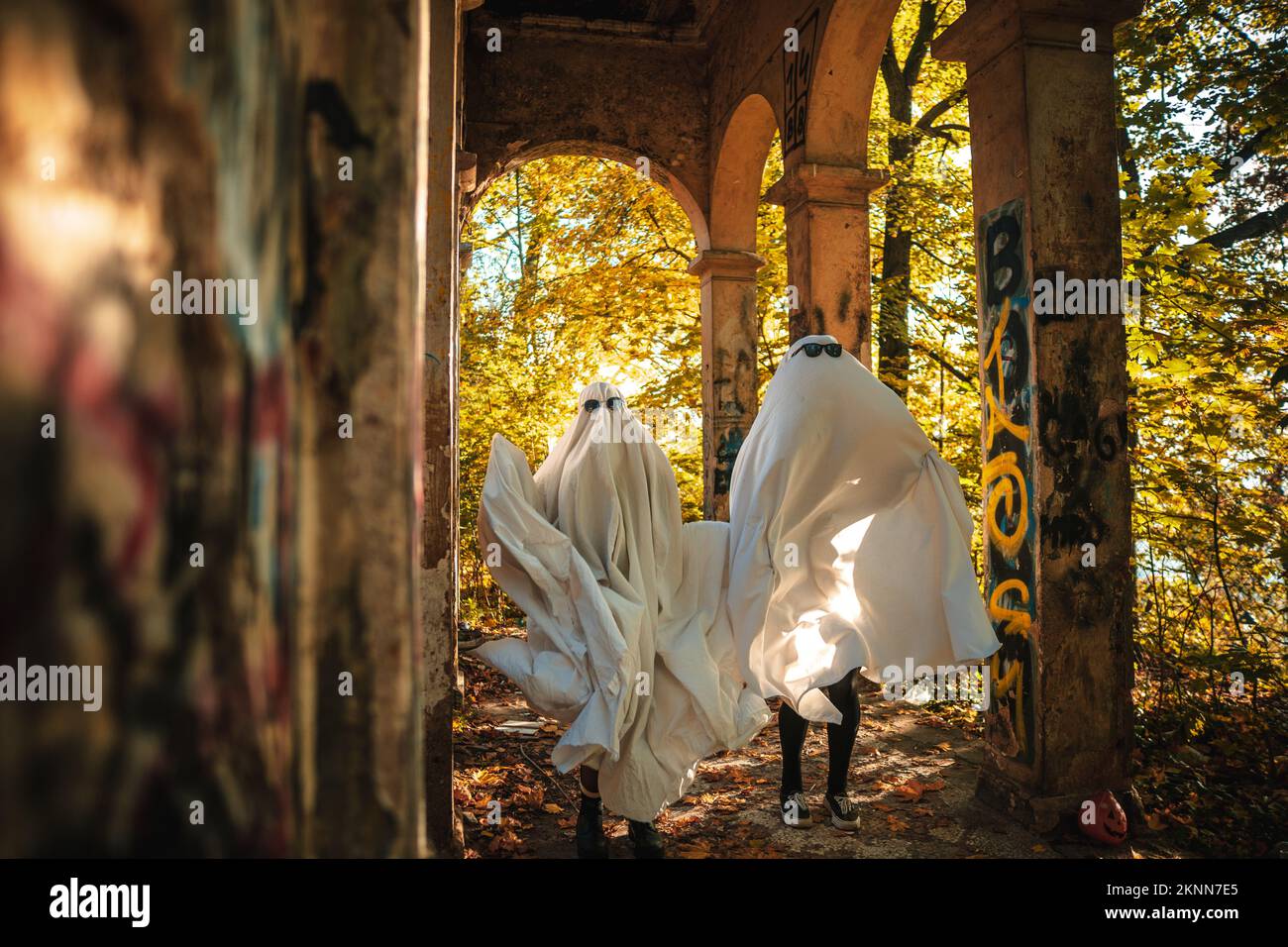 A funny image of two jumping people in ghost costumes and sunglasses in ...