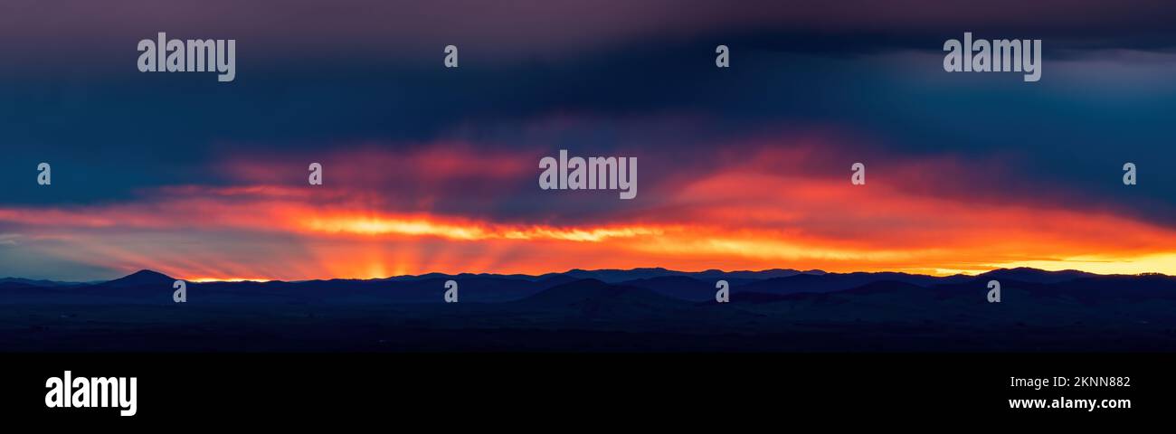 Colorful sunrise with rays and rolling hills Stock Photo - Alamy