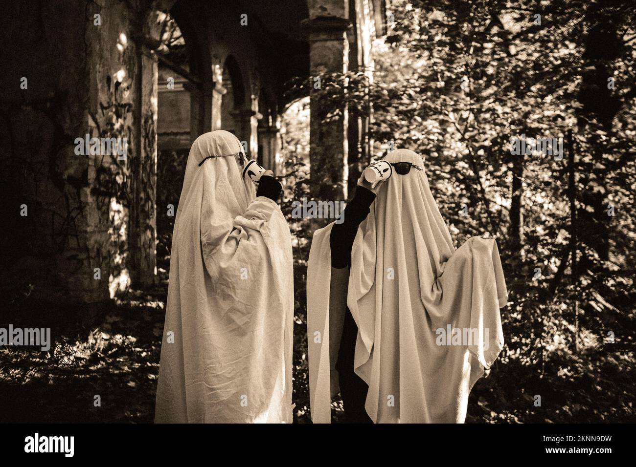 A funny image of two people in ghost costumes and sunglasses holding a ...