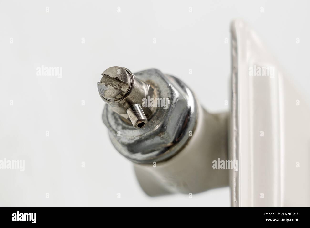 Steel bleed valve in home central heating radiator close up for air ...