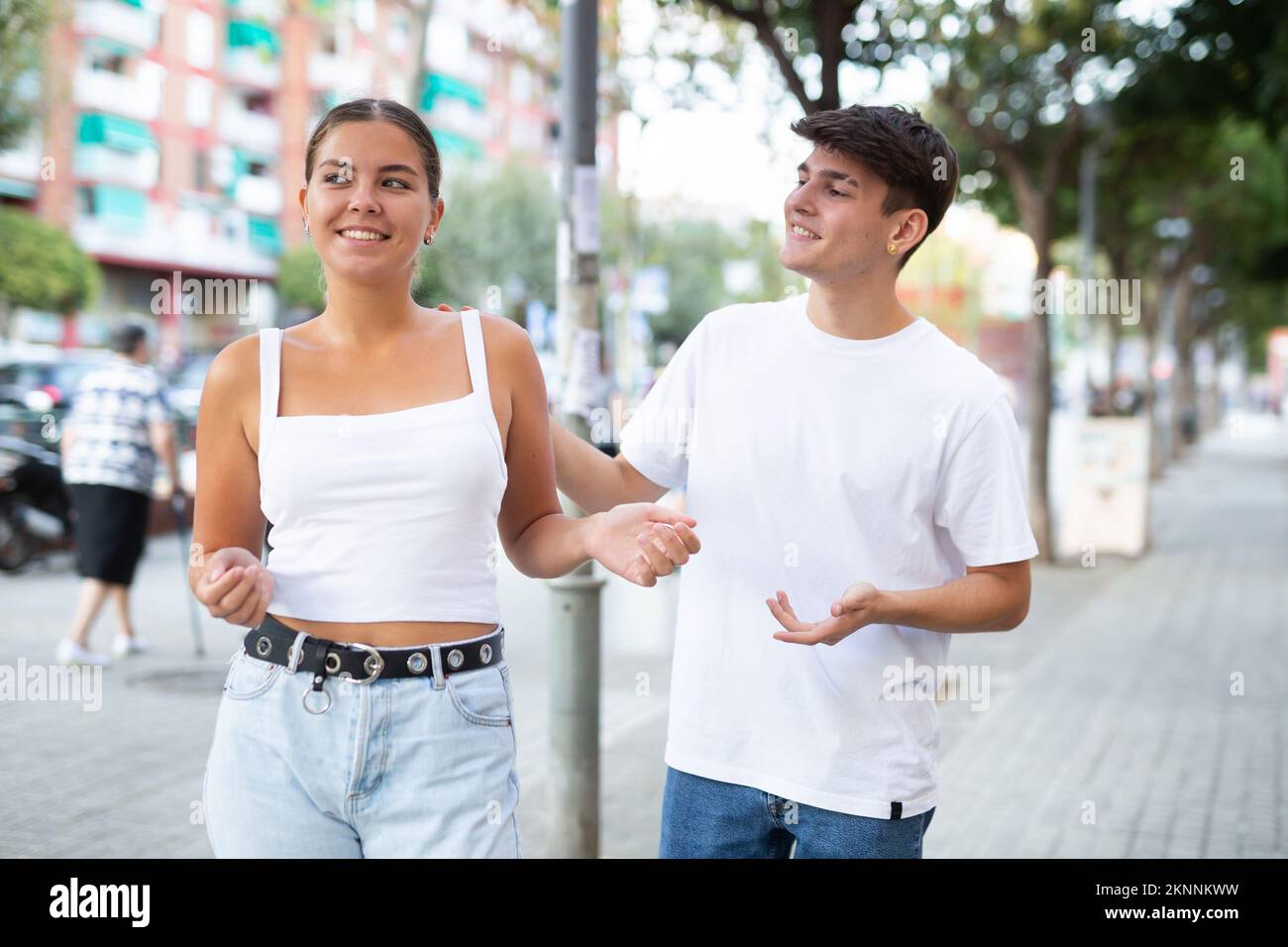 Cheerful guy trying to pick up young stranger girl on city street Stock ...