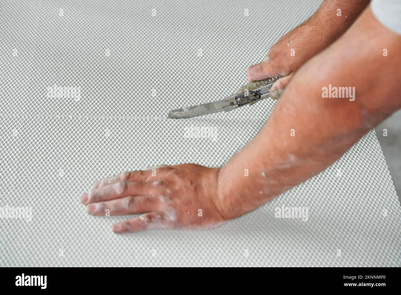 Man cutting polystyrene foam heat insulation with old retractable ...