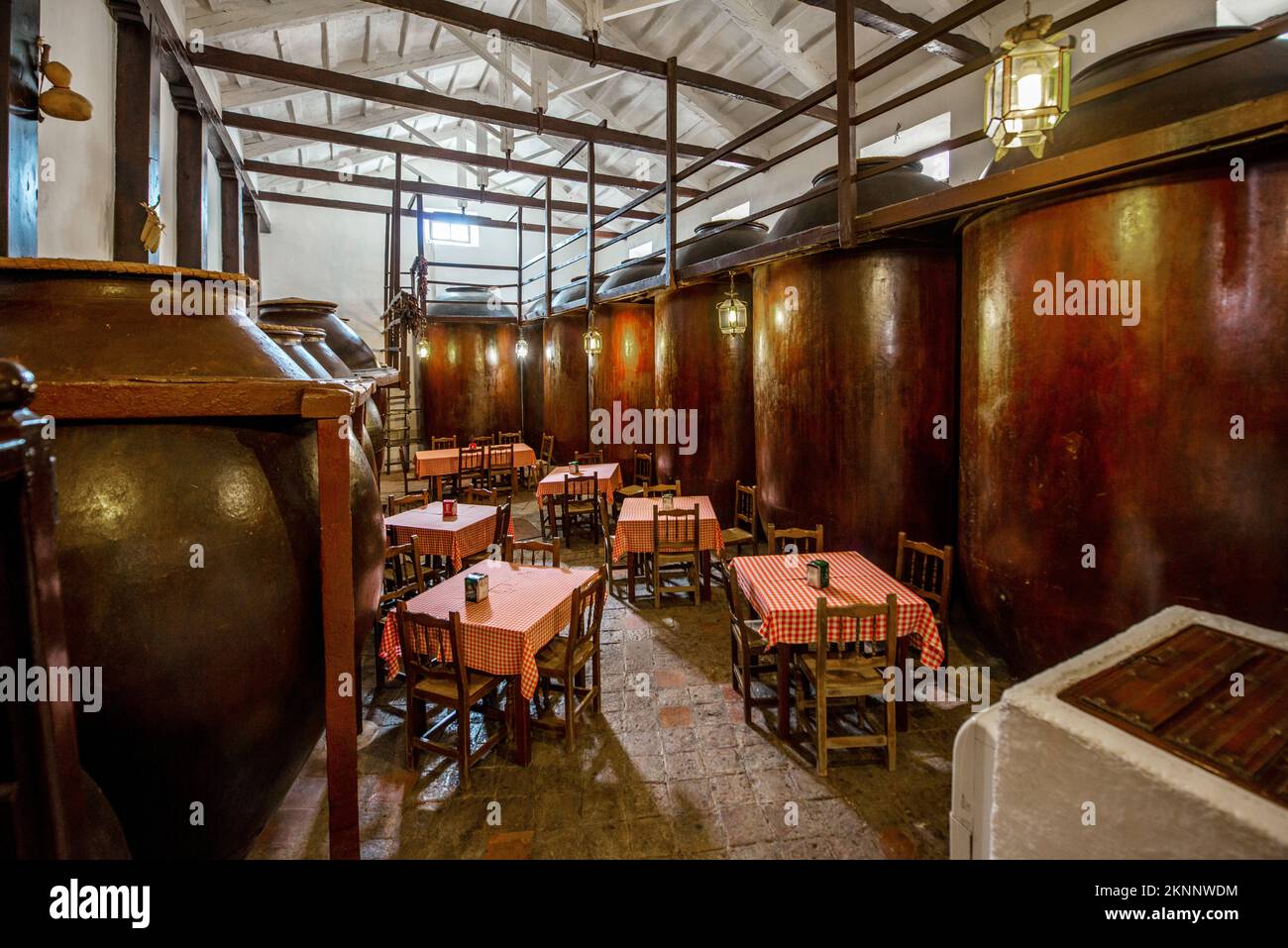 A dining room of an old restaurant with clay vats filled with wine ...