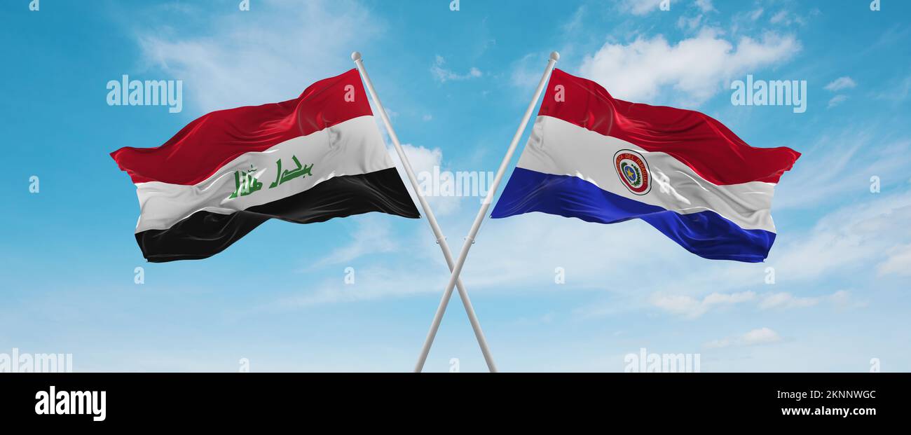 two crossed flags Paraguay and Iraq waving in wind at cloudy sky ...