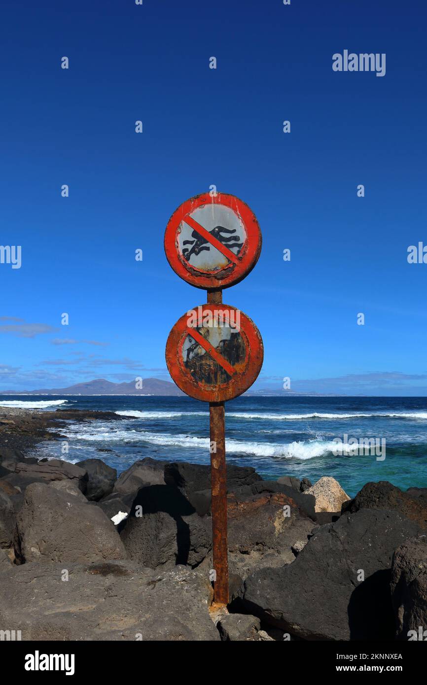 2 well weathered round red warning signs against sea and sky Stock ...