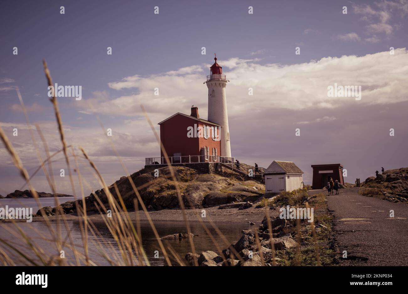 A scenic view of a small lighthouse building built by the shore of a ...